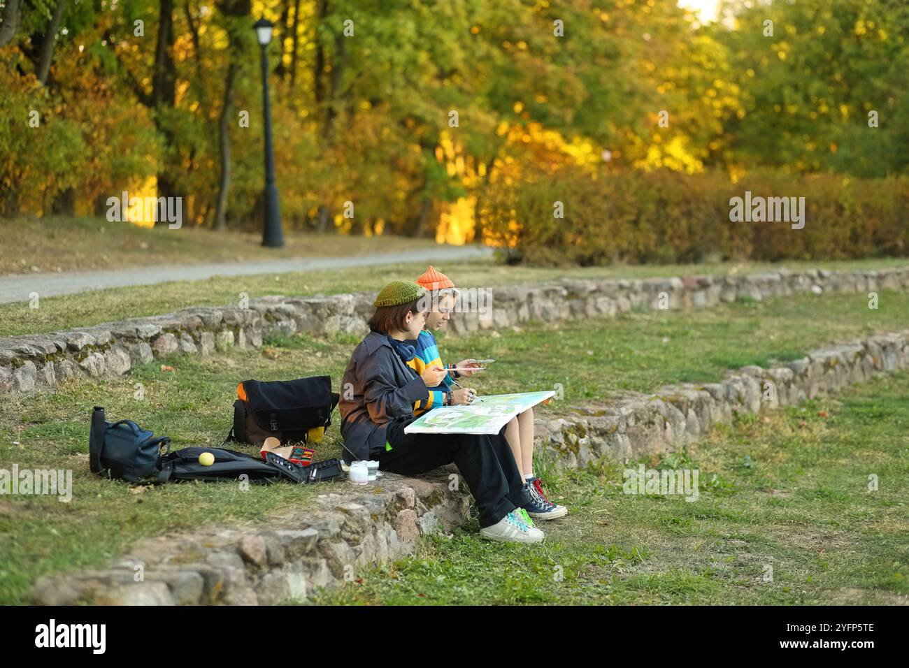 two young and innovative female artists conducting an outdoor painting ...