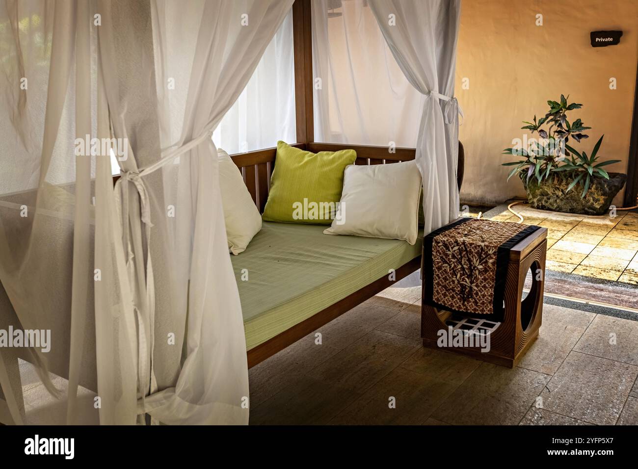 Private guest area in luxury hotel with sun bed, white curtains and bed ...