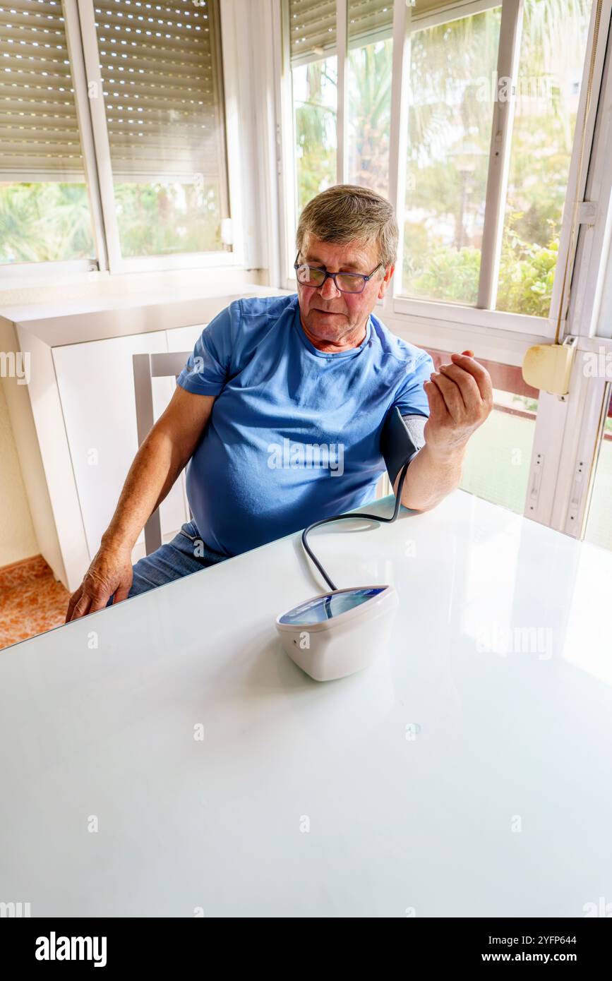 Overweight Senior Man Measuring Blood Pressure with Monitor at Home in ...