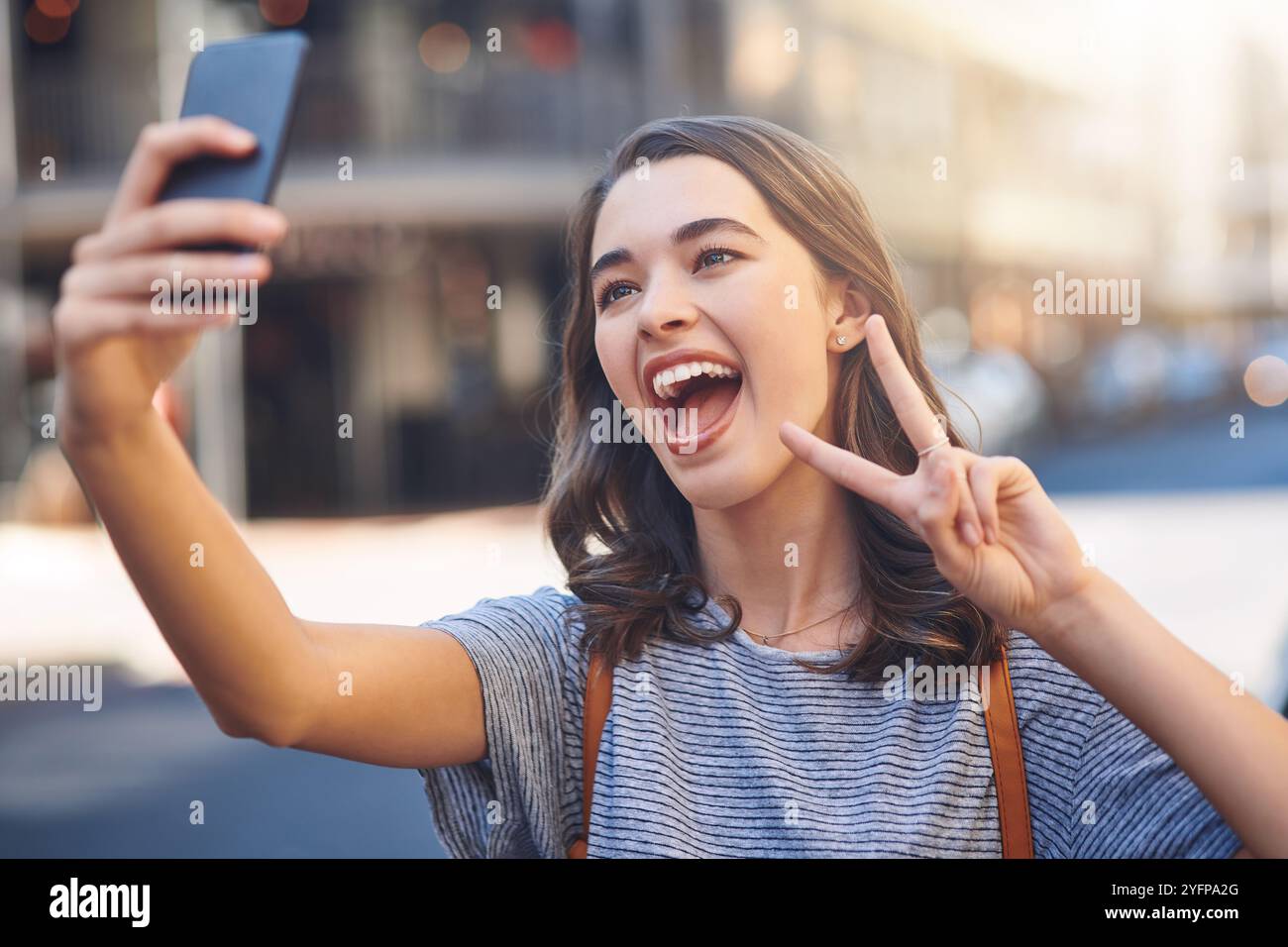 Girl, peace sign and travel in city with selfie for profile picture ...