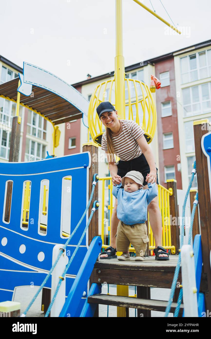 A mother teaches her son to walk, the first steps of a baby. The child ...