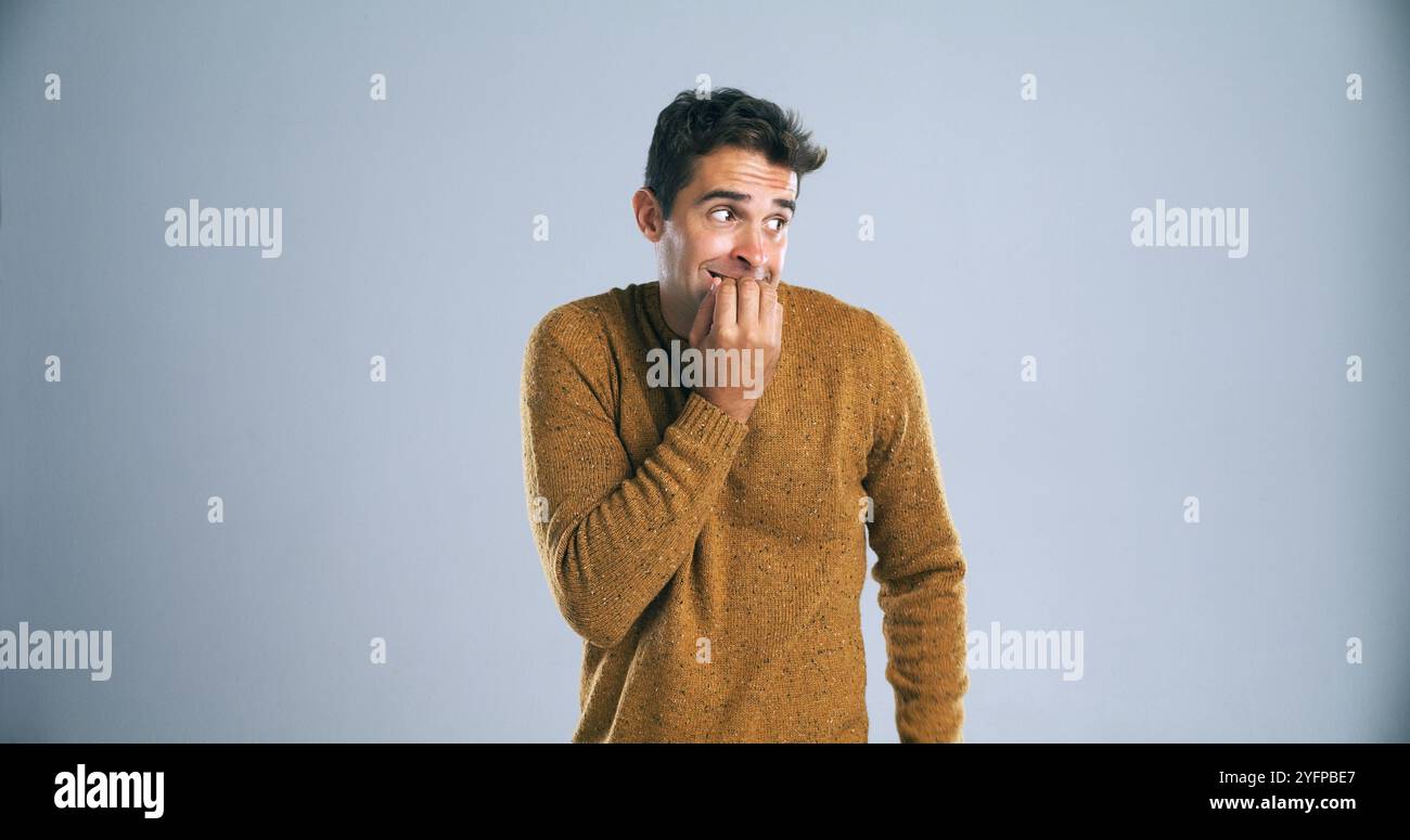 Stress, man and biting nails with fear in studio for horror, terror and ...