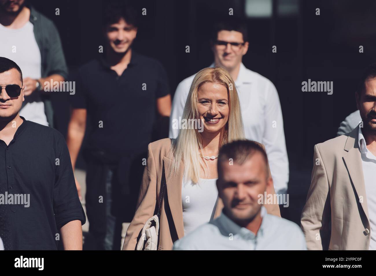 A diverse group of businessmen and colleagues walking together by their ...