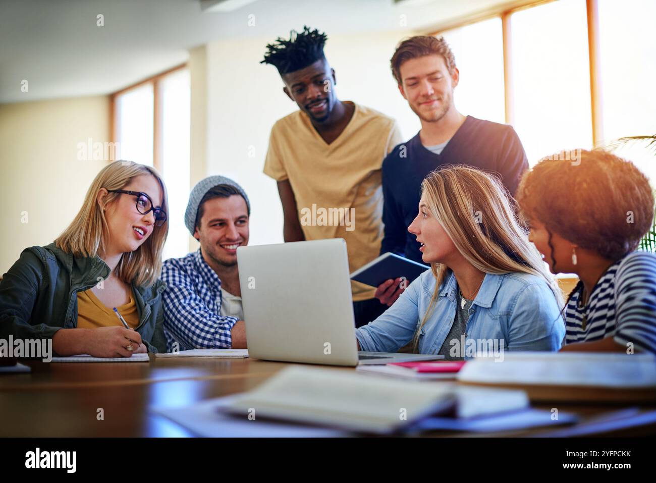 Education, laptop and student friends in library together for learning ...
