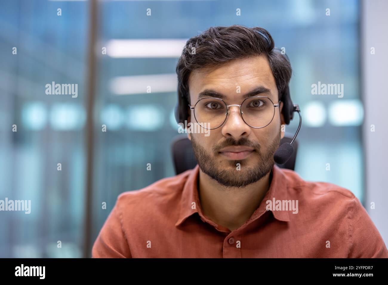 Confident hispanic business man wearing headset, seated in modern ...