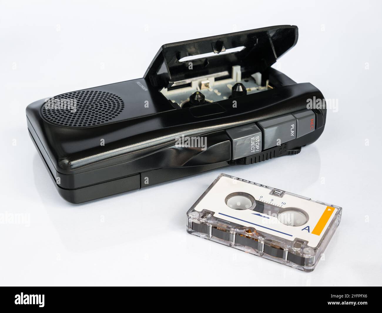 Audio micro cassette recorder and micro cassette tape in foreground ...
