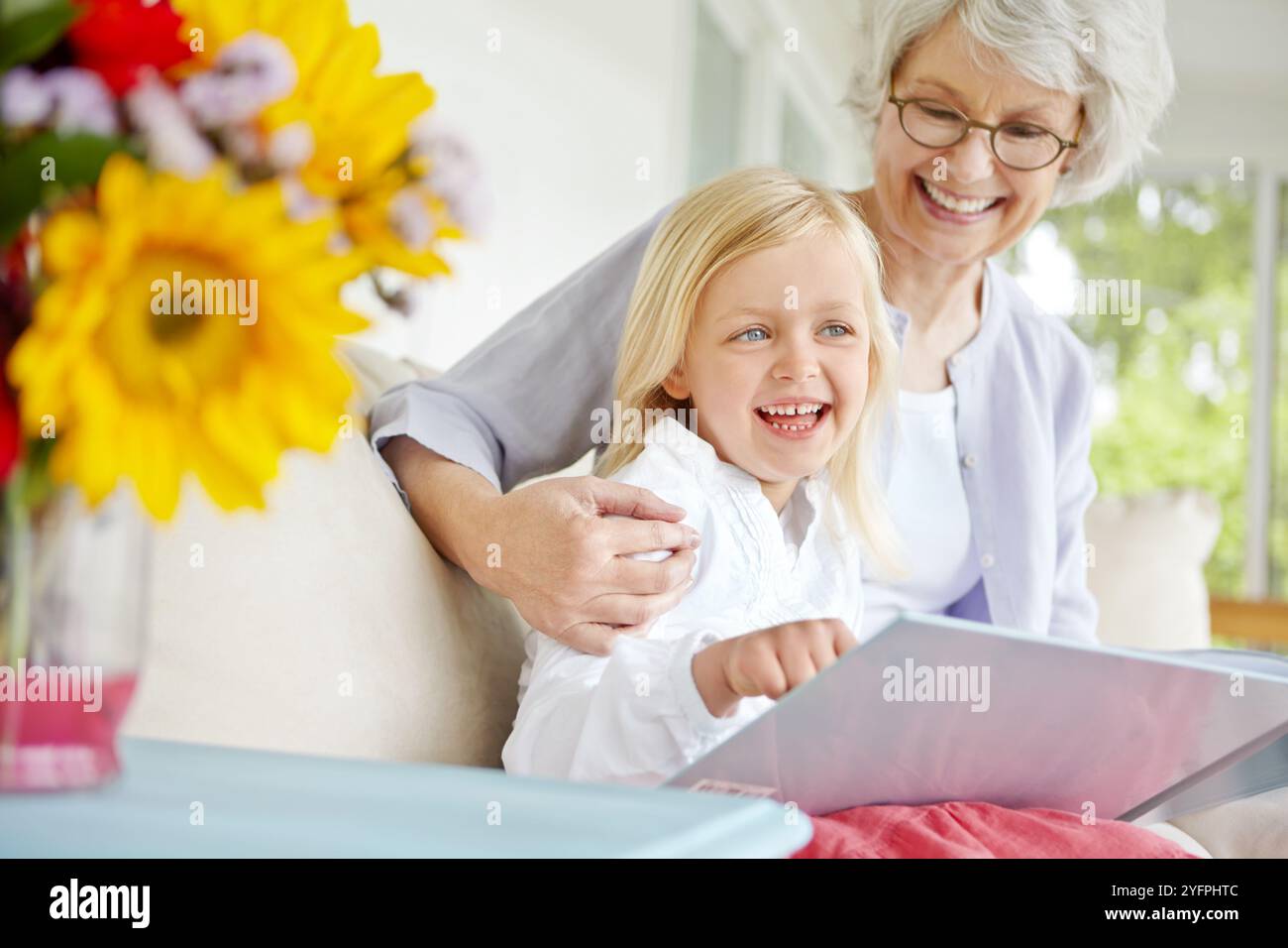 Grandma, happy and girl reading book in home for learning, bonding and ...