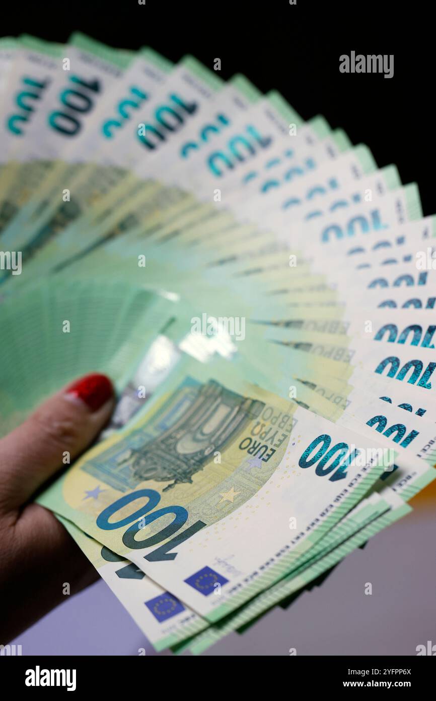 Woman hand holding one hundred European euros banknotes money, spending ...