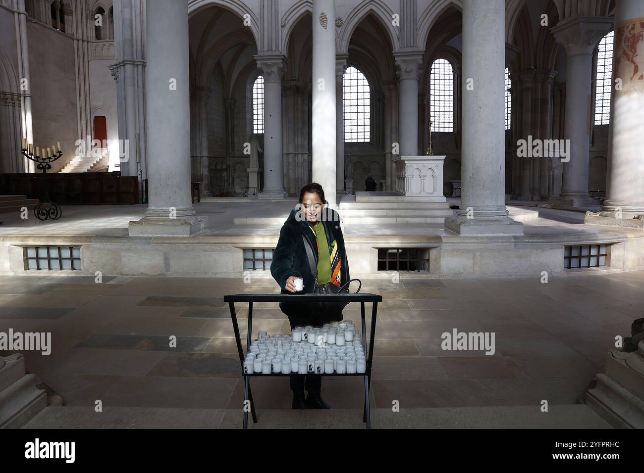 Woman lighting a candle in Vezelay abbey, in French Sainte-Marie ...