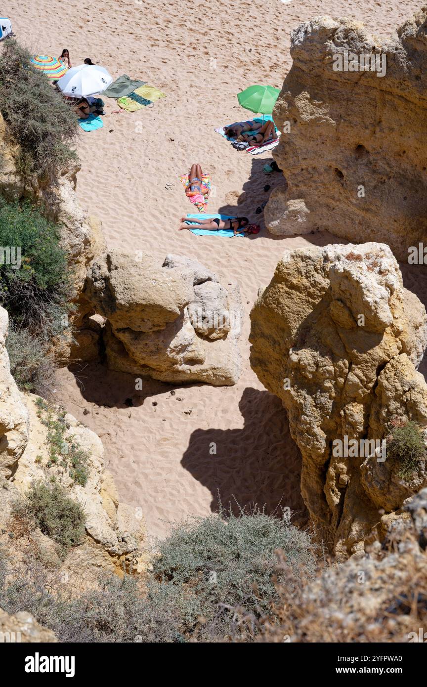 Hidden beach alcove at Praia de São Rafael, sunbathers relax between ...