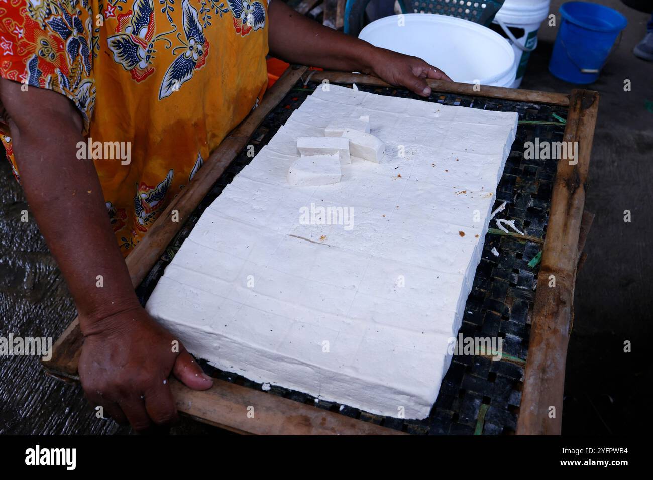 Worker making tofu in a traditional family factory. Tofu is a food ...