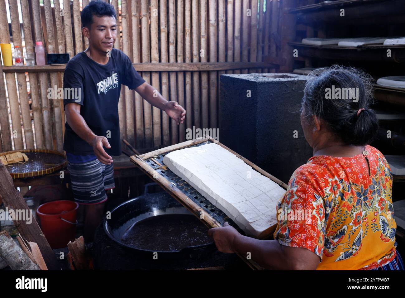 Worker making tofu in a traditional family factory. Tofu is a food ...