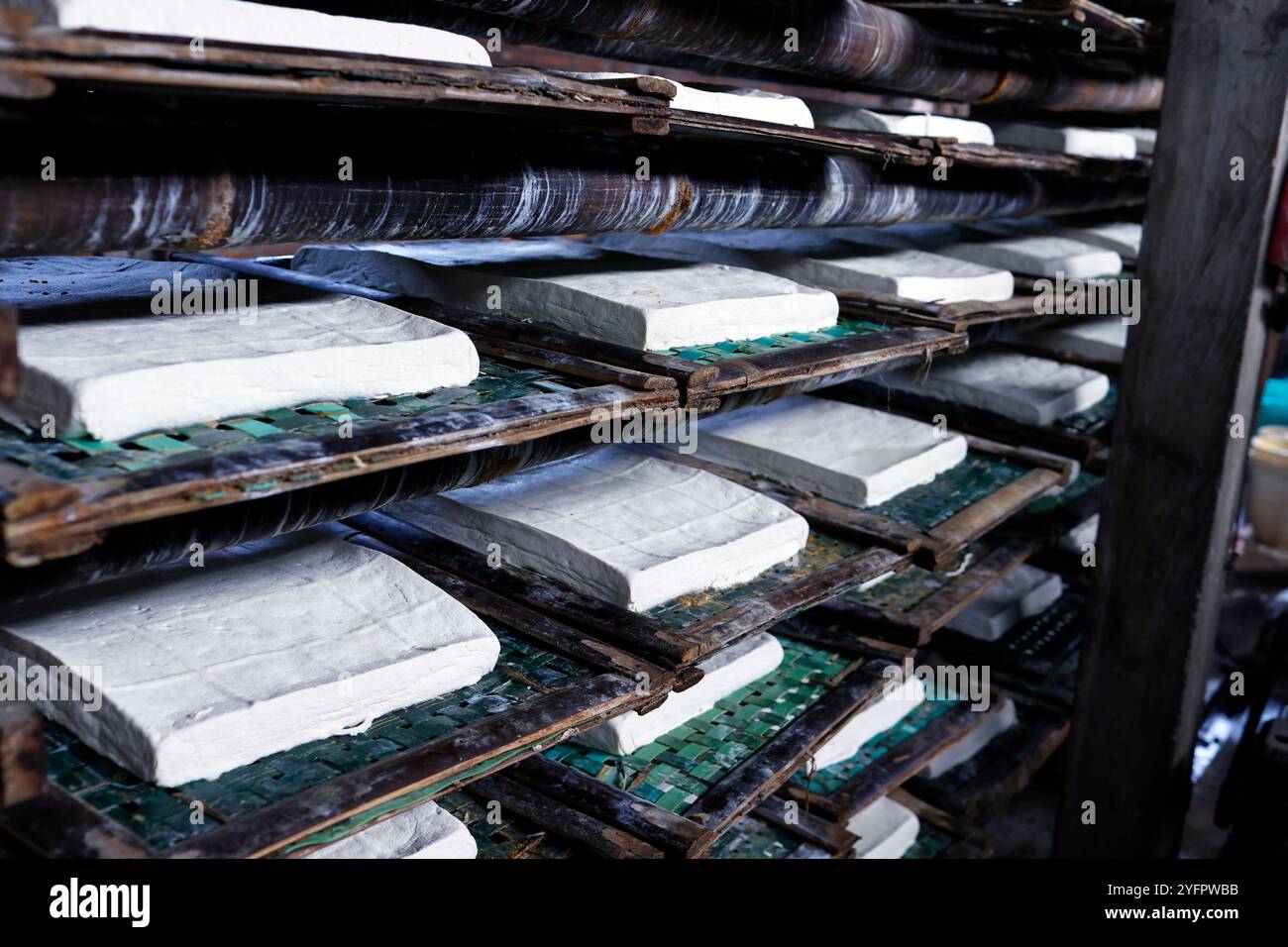 Worker making tofu in a traditional family factory. Tofu is a food ...