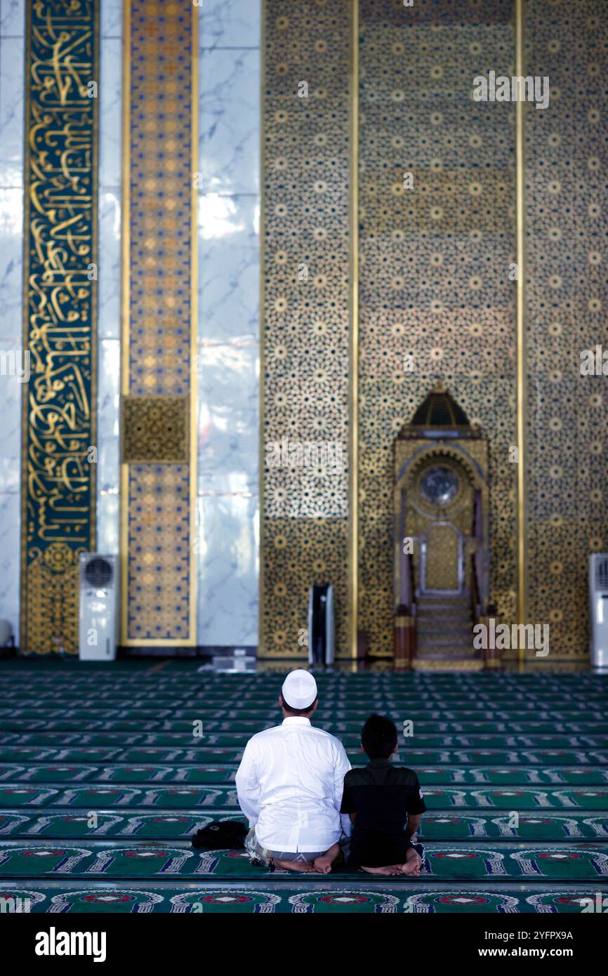 Al Akbar Surabaya National Mosque. Father andson praying and whorship ...