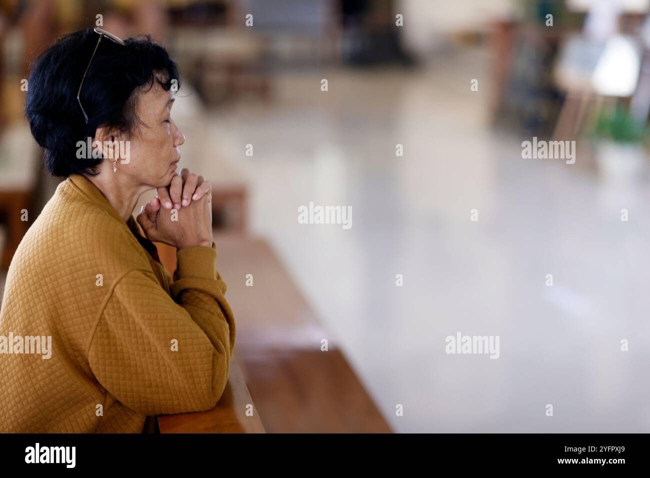 Ganjuran Church. The Church of the Sacred Heart of Jesus. Woman praying in the church ...