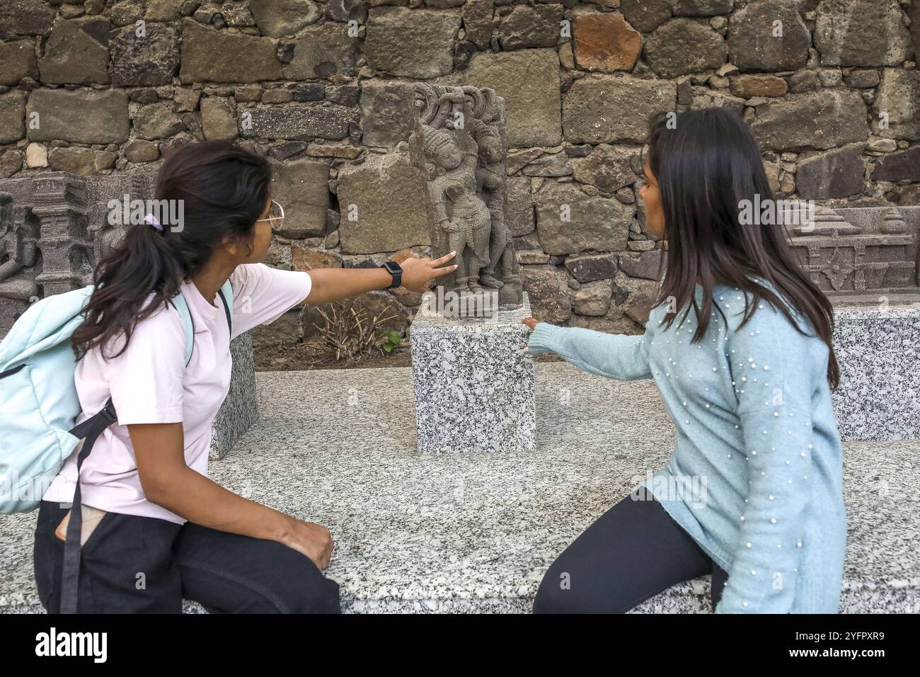 Hindu students touching a statue in Daulatabad fort, Maharashtra, India ...
