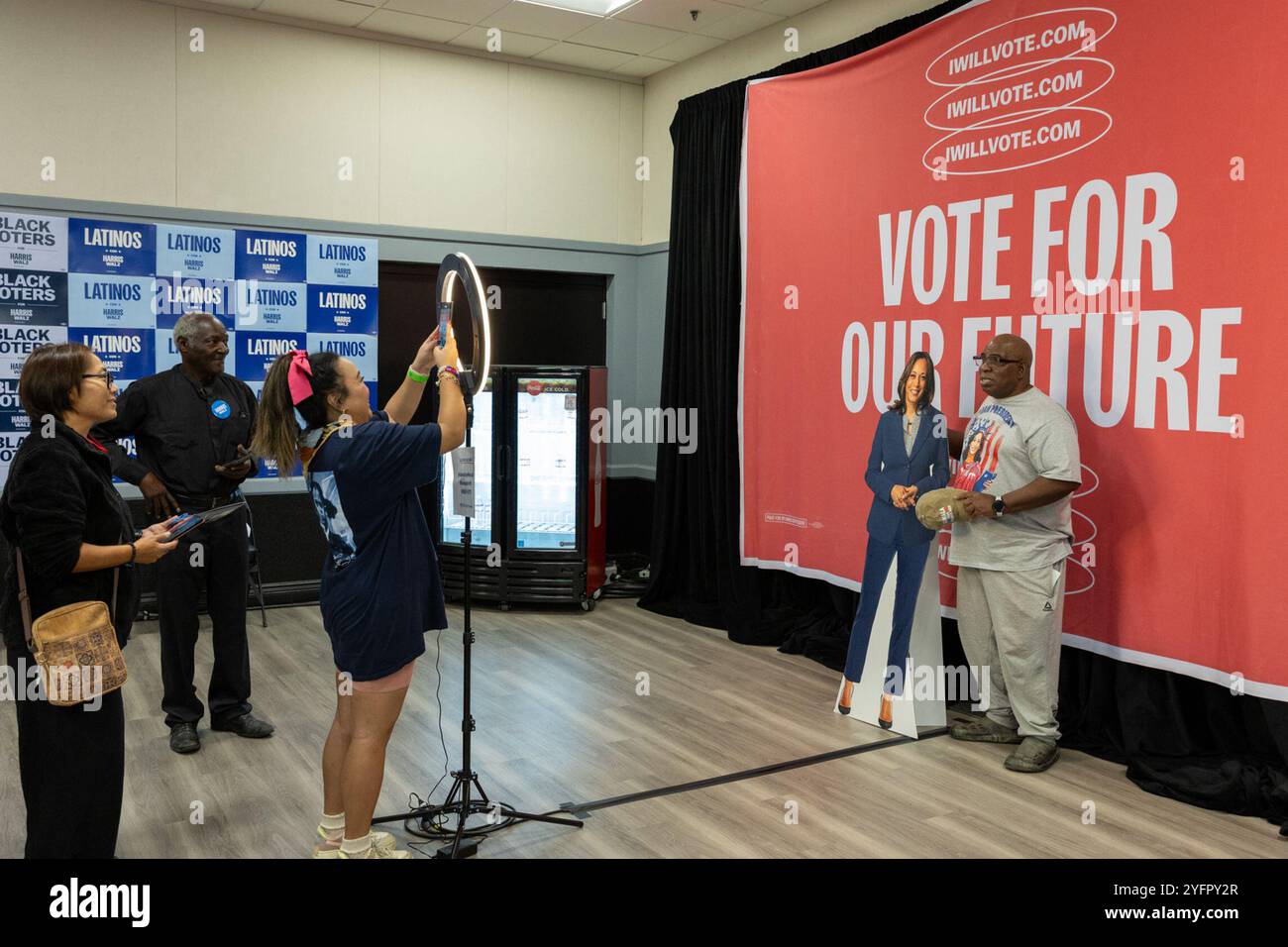 An audience member poses with a cardboard Kamala Harris at the When We ...