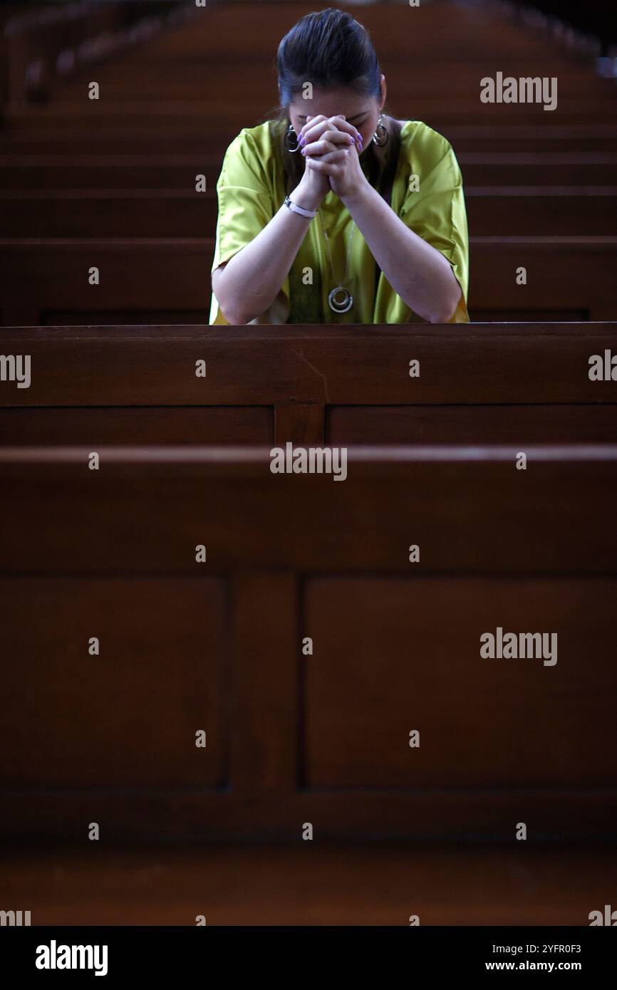 Catholic woman praying alone in a church Stock Photo - Alamy