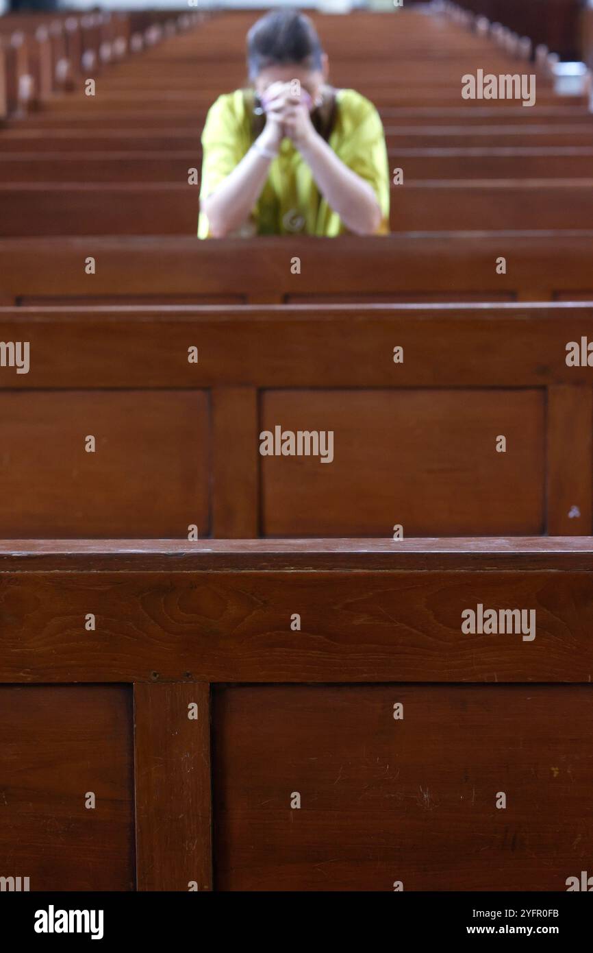 Catholic woman praying alone in a church Stock Photo - Alamy