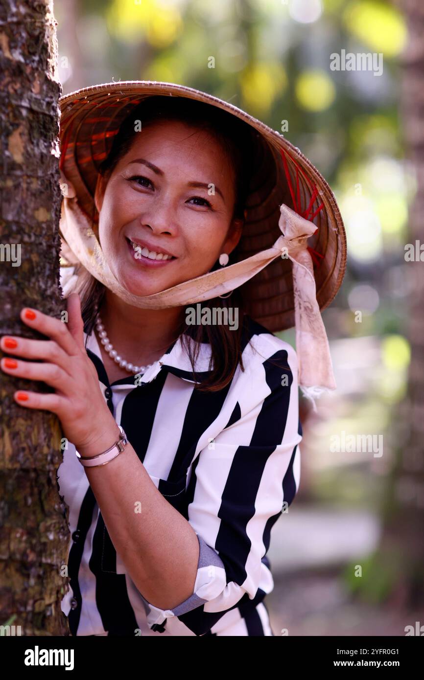 Vietnamese woman wearing a tradional palm leaf conical hat. Portrait ...