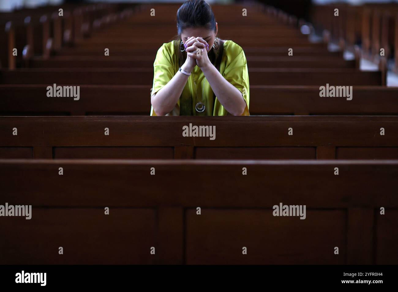 Catholic woman praying alone in a church Stock Photo - Alamy