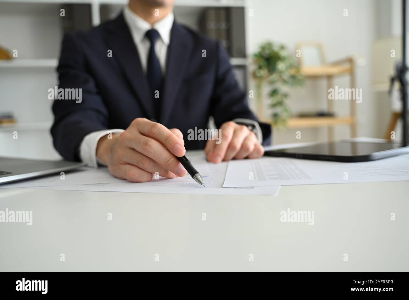 Professional businessperson reviewing contract documents at work desk ...