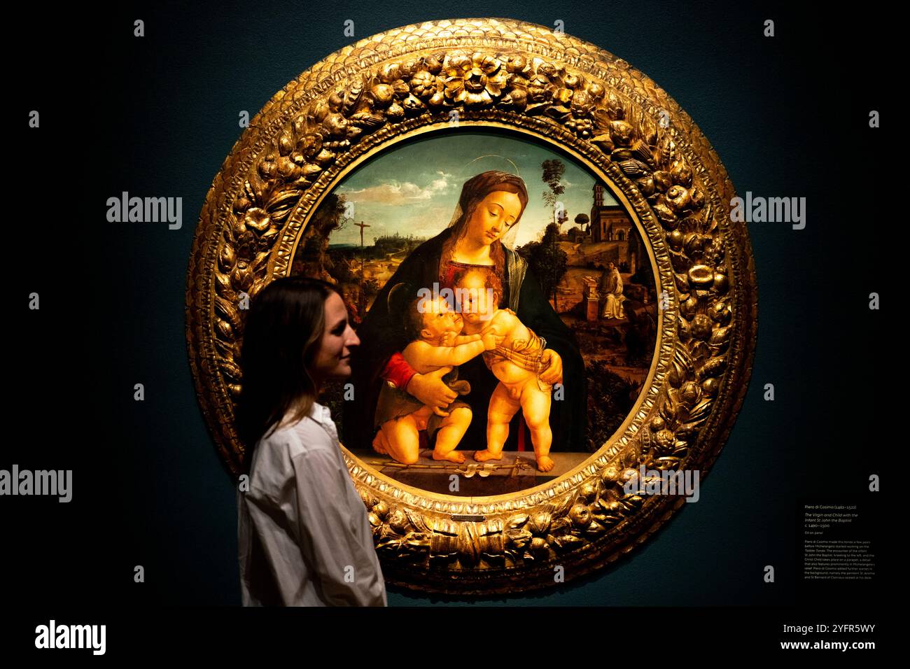 A gallery assistant with The Virgin and Child with the Infant St John ...