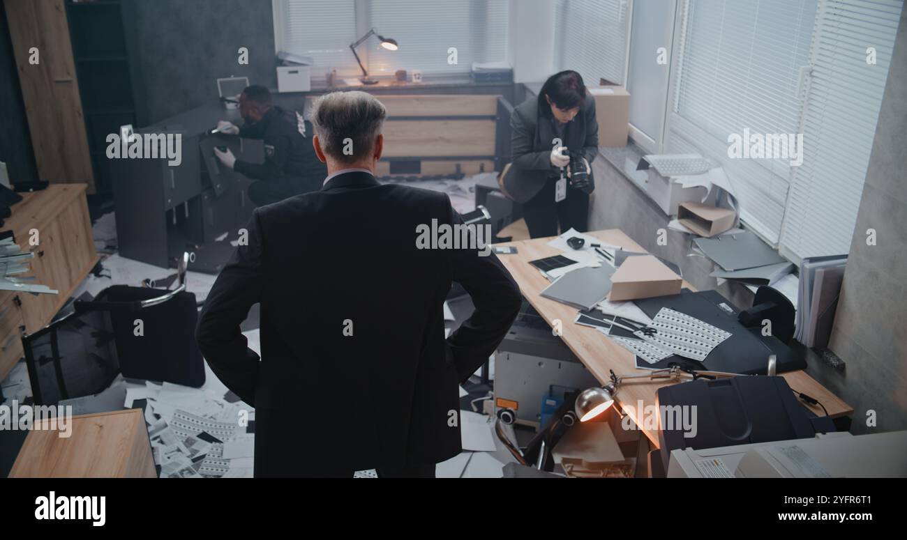 Office robbery case: High angle of detective examining crime scene ...