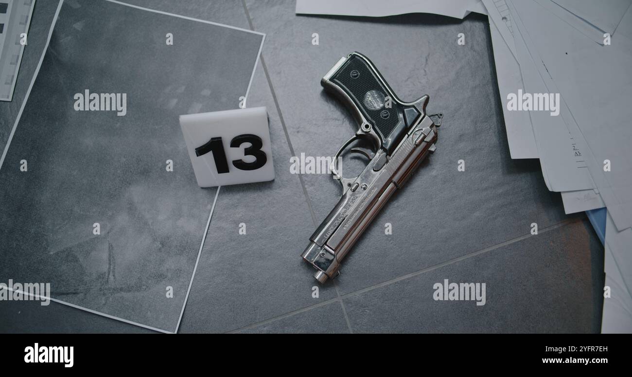 Bank robbery or murder case. Top view on murder weapon gun lying next ...