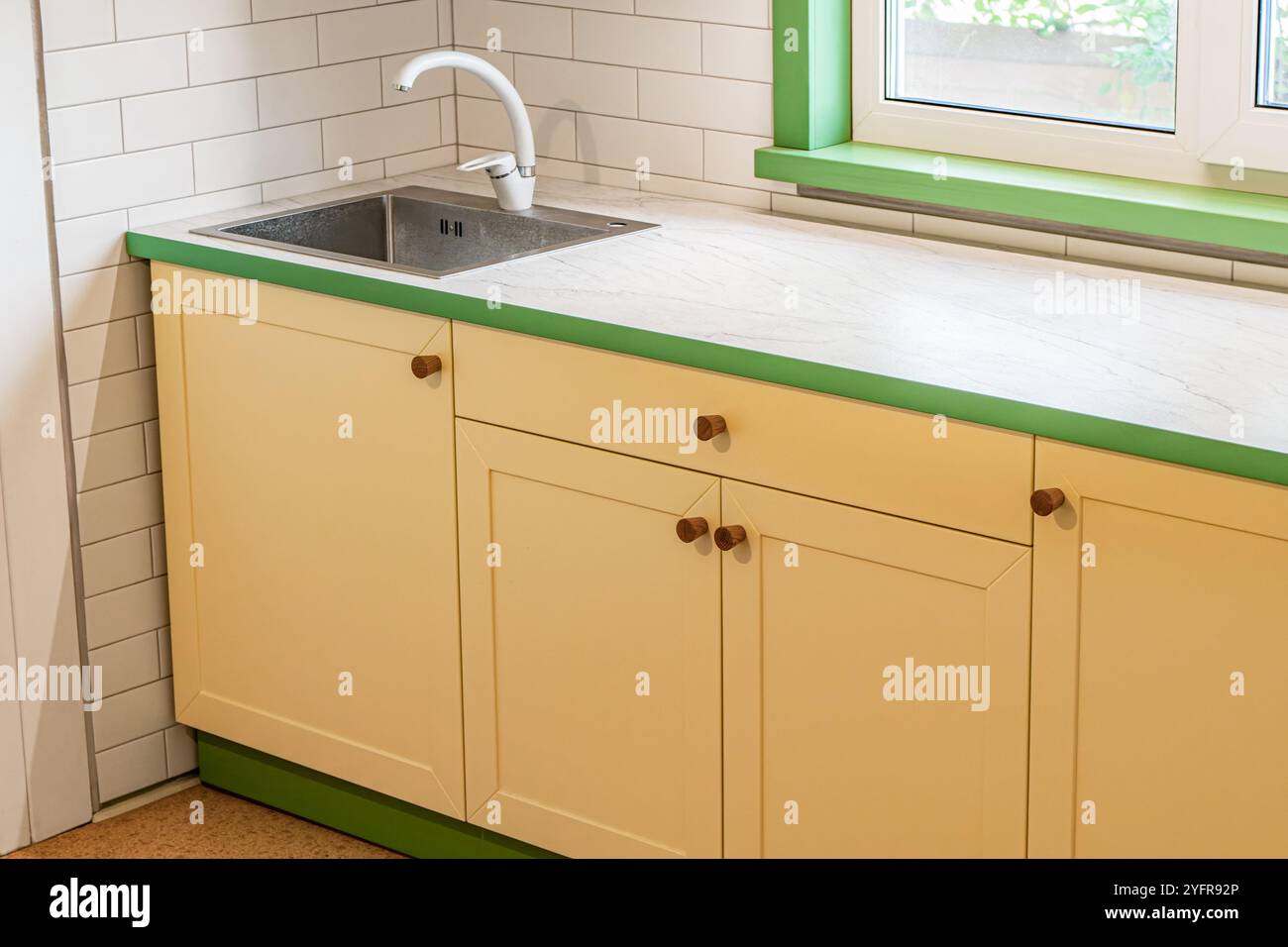 Kitchen with yellow cabinets with wooden handles and plastic countertop ...