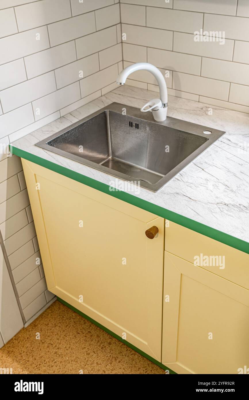 Kitchen with yellow cabinets with wooden handles and plastic countertop ...