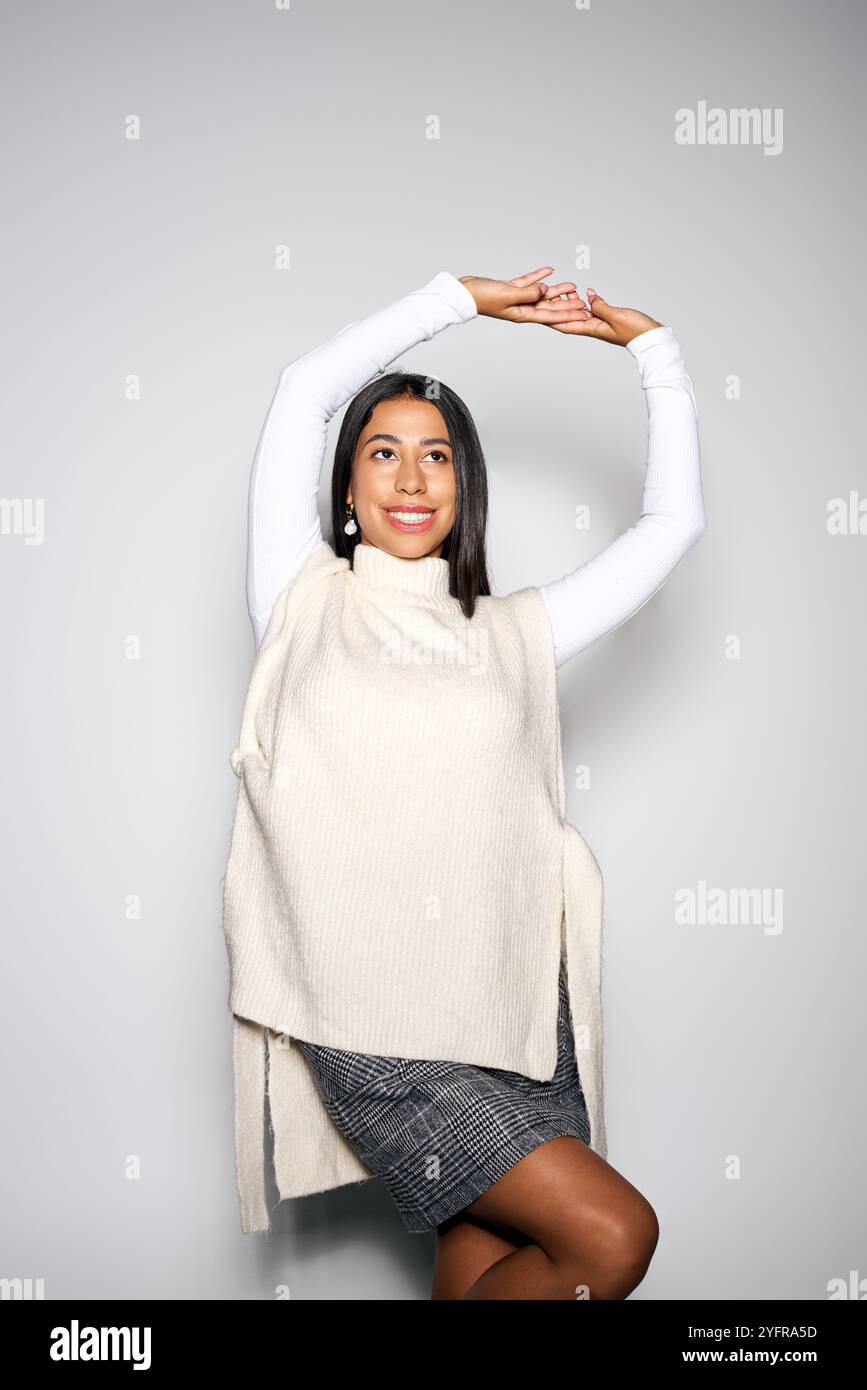 A stylish young woman with a radiant smile poses confidently against a ...