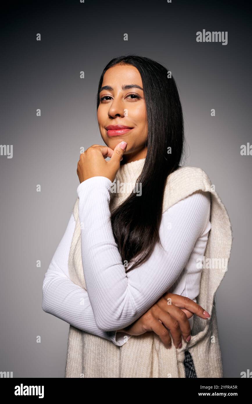 A young beautiful woman stands confidently, her graceful pose ...