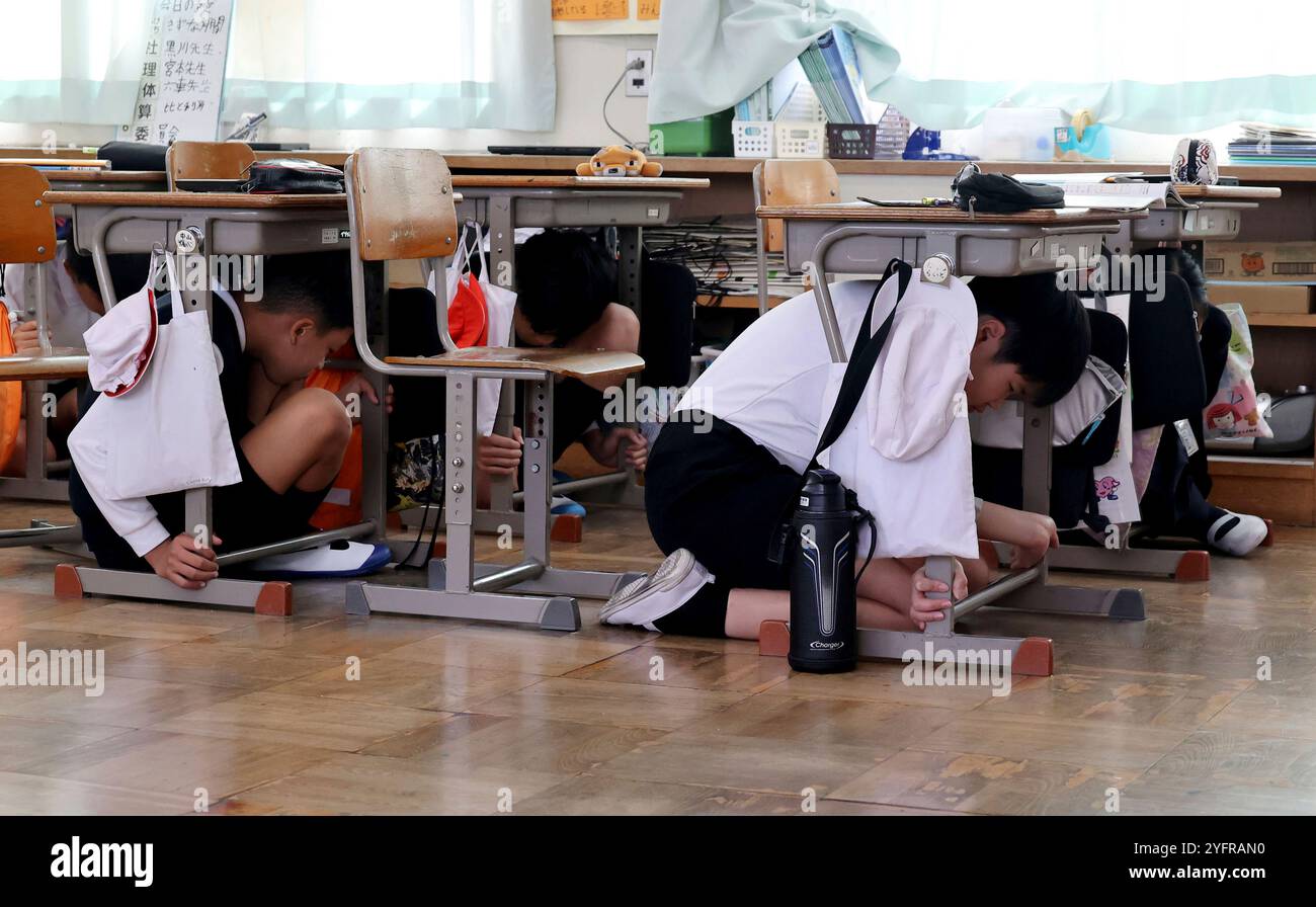Elemantary school students crouch under desks during a drill simulating ...