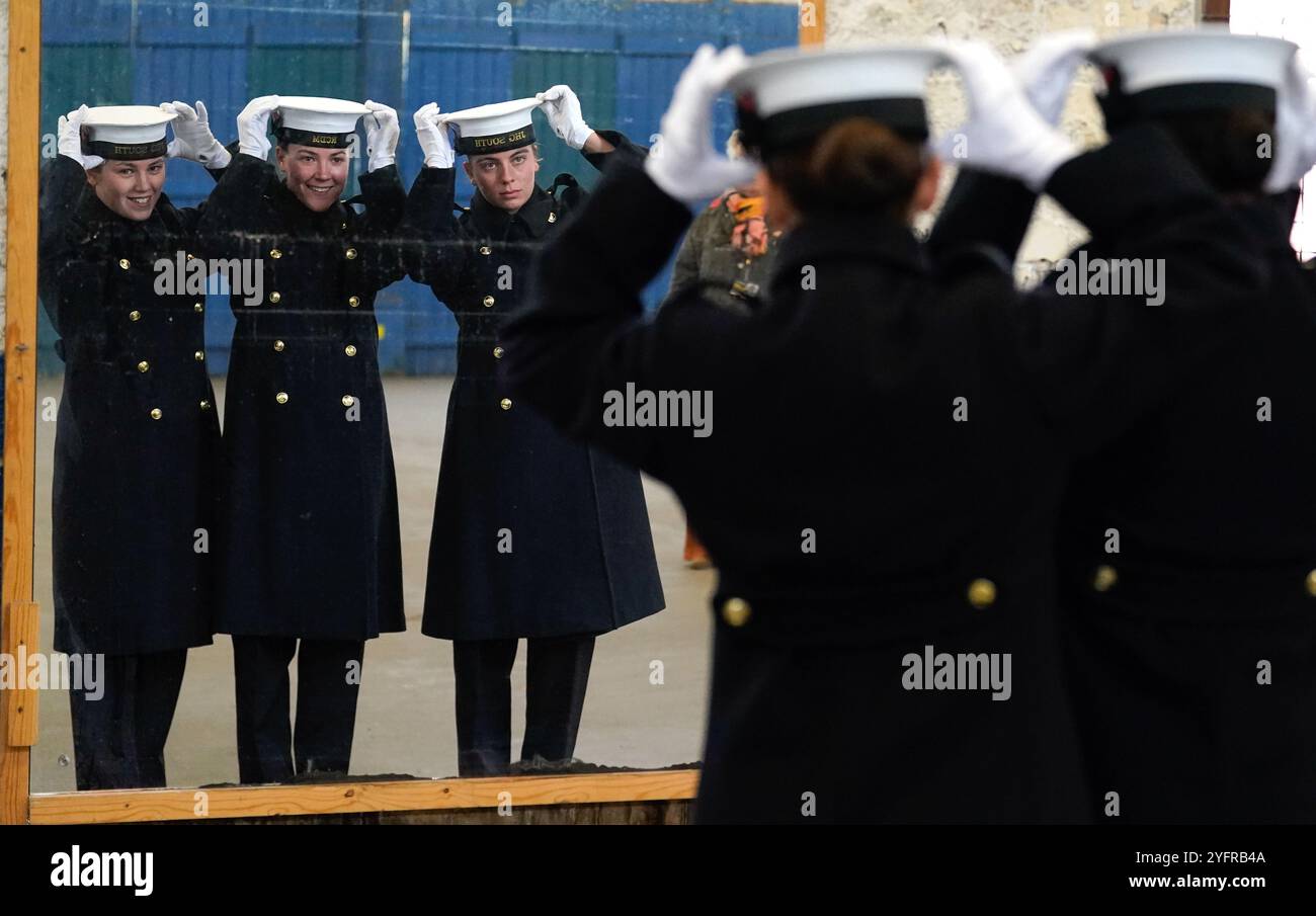 Royal Navy ratings use a mirror to adjust their uniforms before joining ...