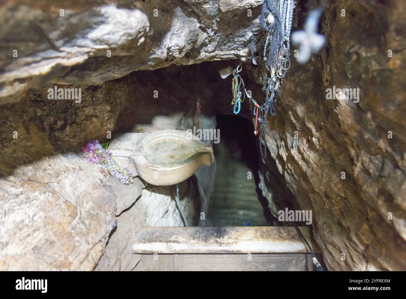Ancient water channel in a cave, surrounded by rock formations and ...