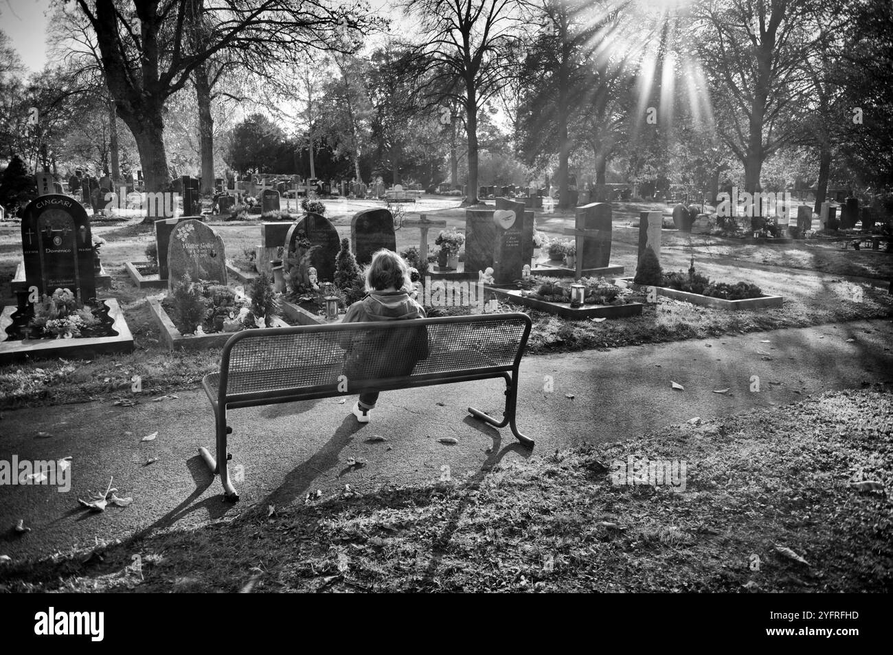 Elderly woman sitting on bench, looking at grave, graves, Tauer ...