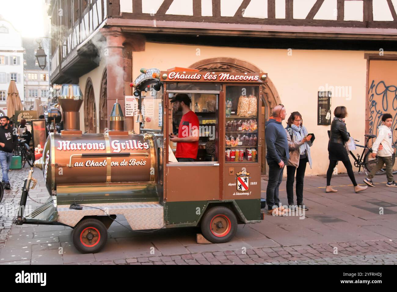 A street food vendor in train shaped food cart, Marrons Grilles, sells ...