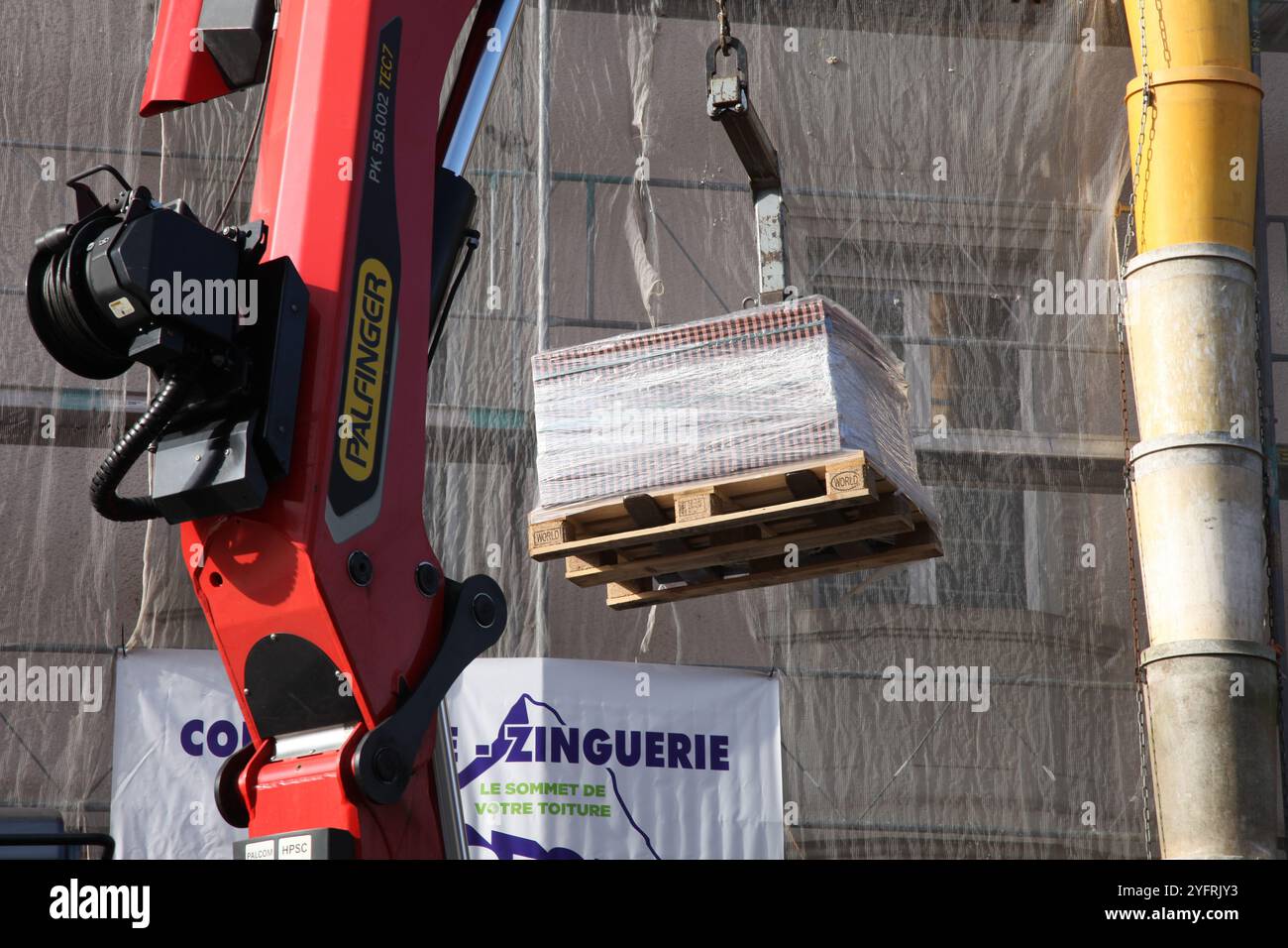 Building works, crane lifting pallet, waste chute, construction site ...