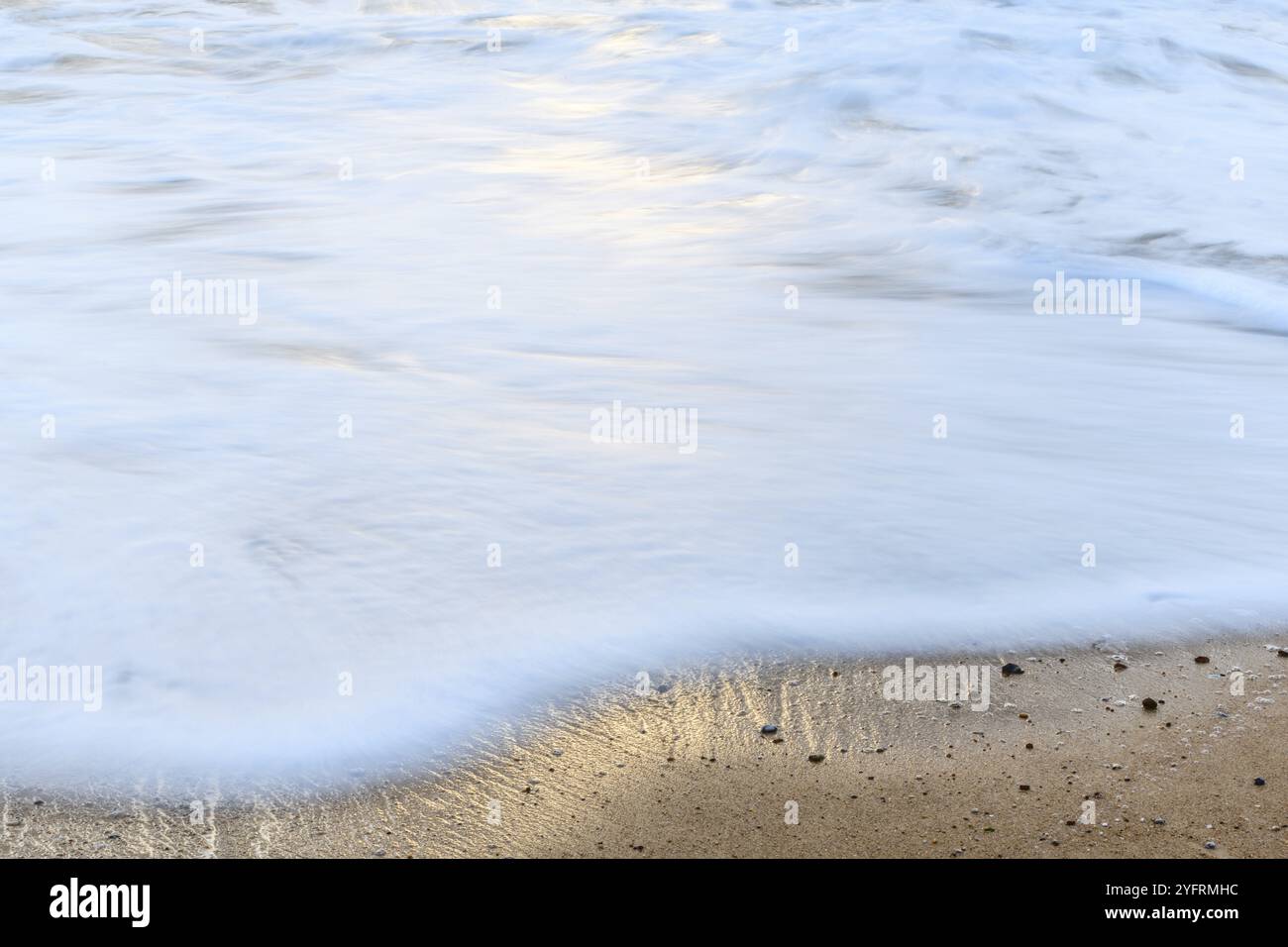 Beach in the evening with moving water which brings an effect to the ...