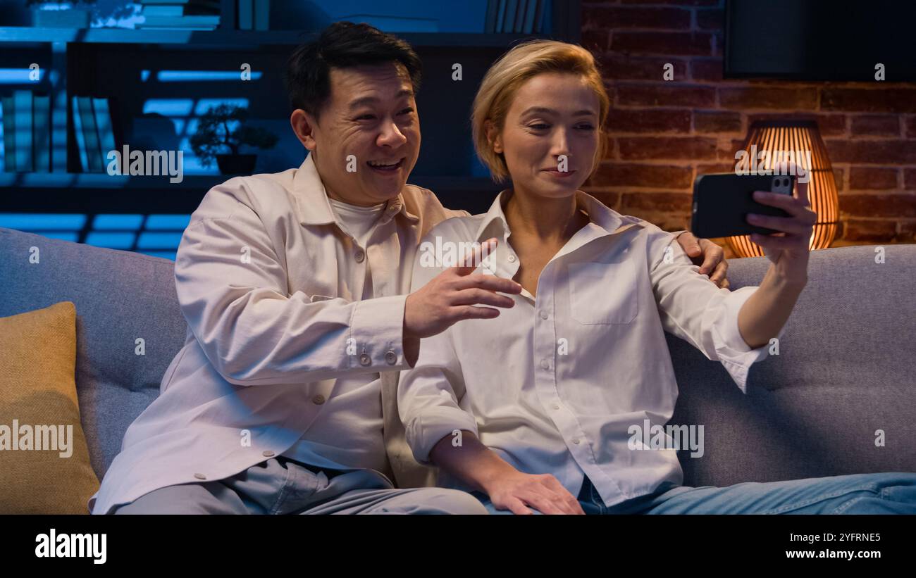 Happy excited multiracial multiethnic couple married diverse Asian man and Caucasian woman ...