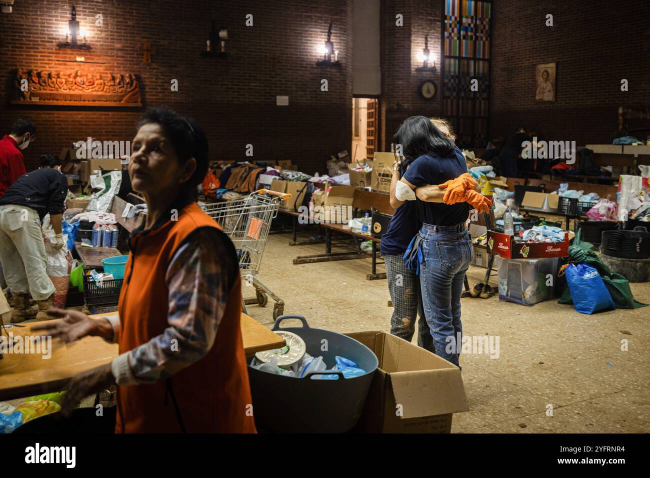 Two people embrace emotionally during the distribution of resources to ...