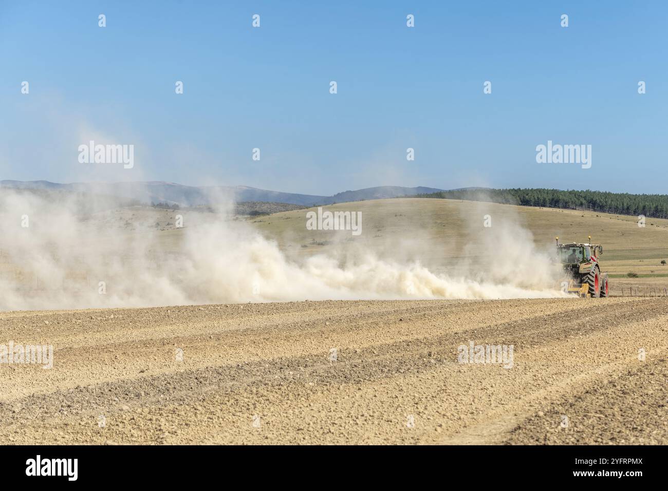 Dust cloud lifted by tractor in times of drought. Cevennes, massif ...