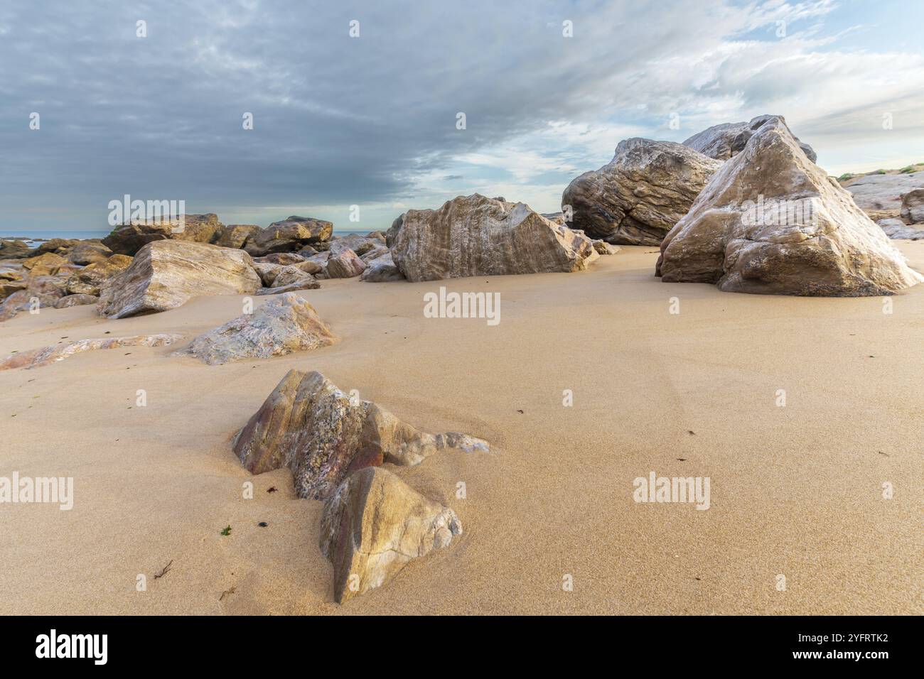 Rocks polished by waves of Atlantic Ocean on sandy beach. Sables d ...