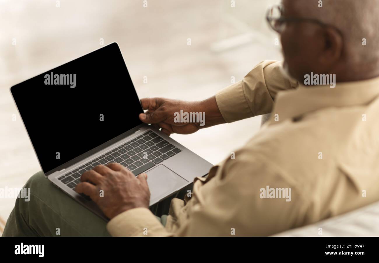 Senior Black Man Using Laptop With Empty Screen Indoors, Back-View Stock Photo - Alamy