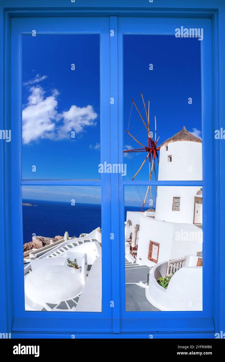 Oia village with windmill through blue window on Santorini island in ...