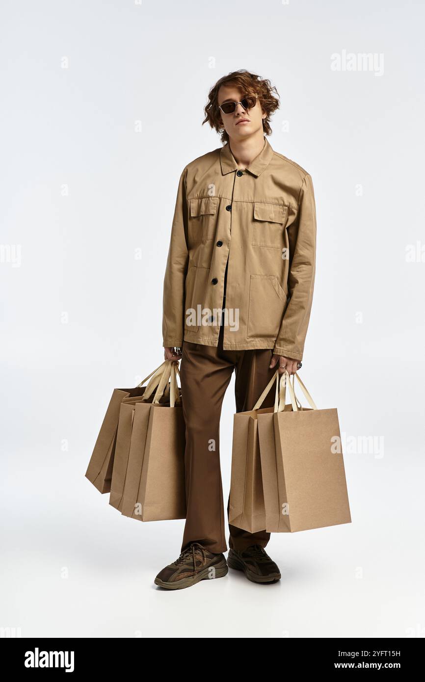 A handsome young man in an elegant autumn outfit stands confidently ...