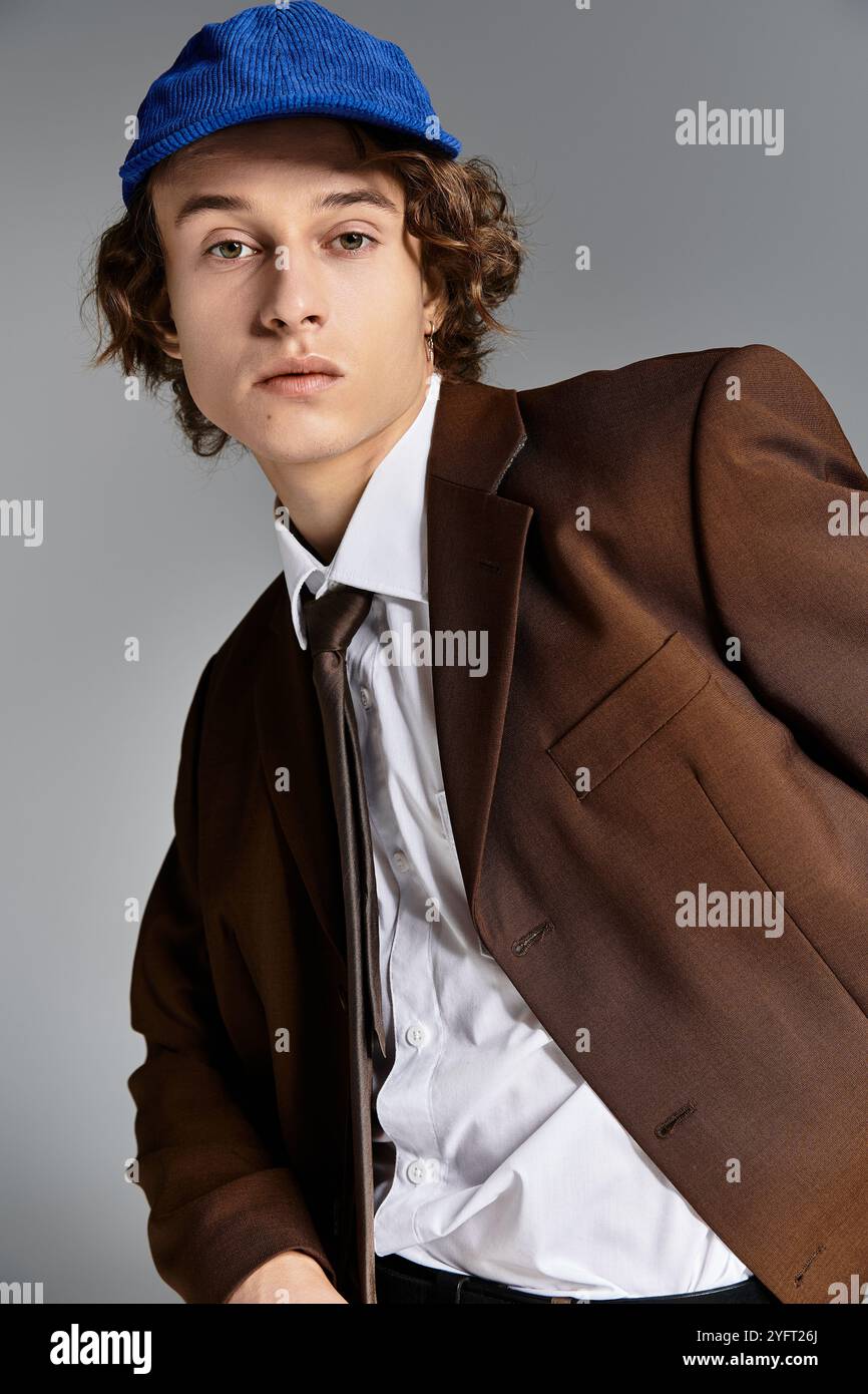 In a chic studio, a handsome young man dressed in a brown suit and ...