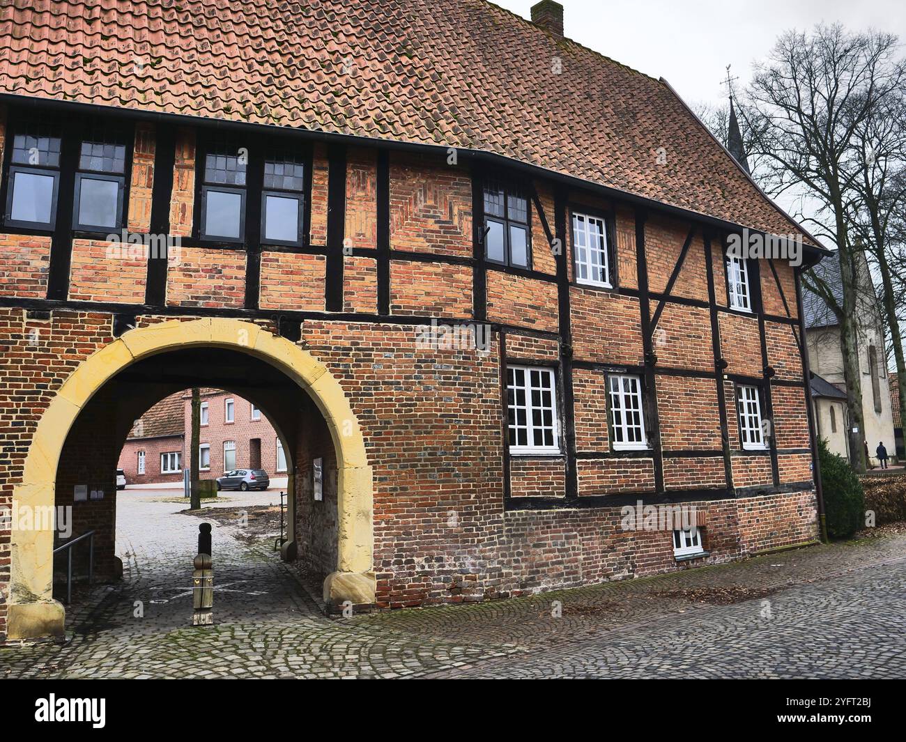 Historic half-timbered house with archway and cobblestones, surrounded ...