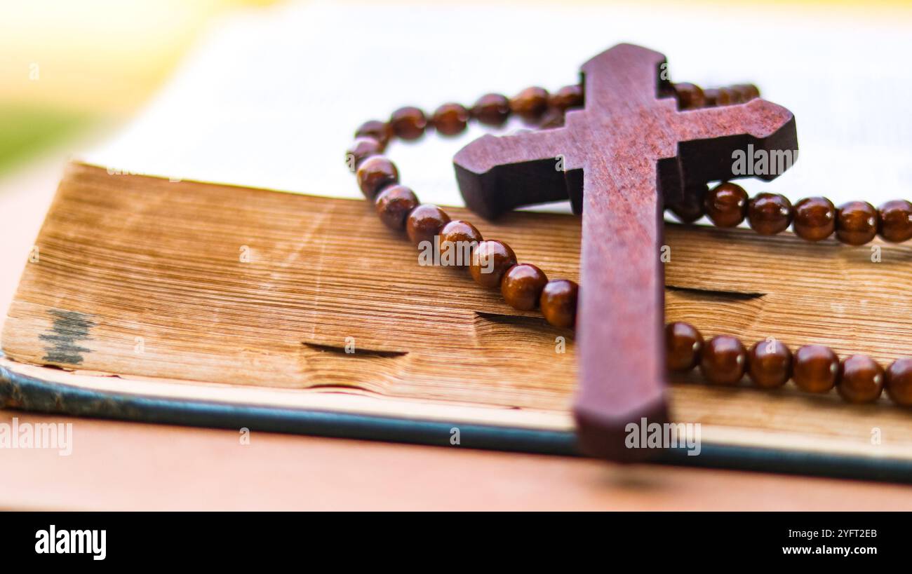 Brown wooden cross on an old open book symbolizing the spread of Jesus ...